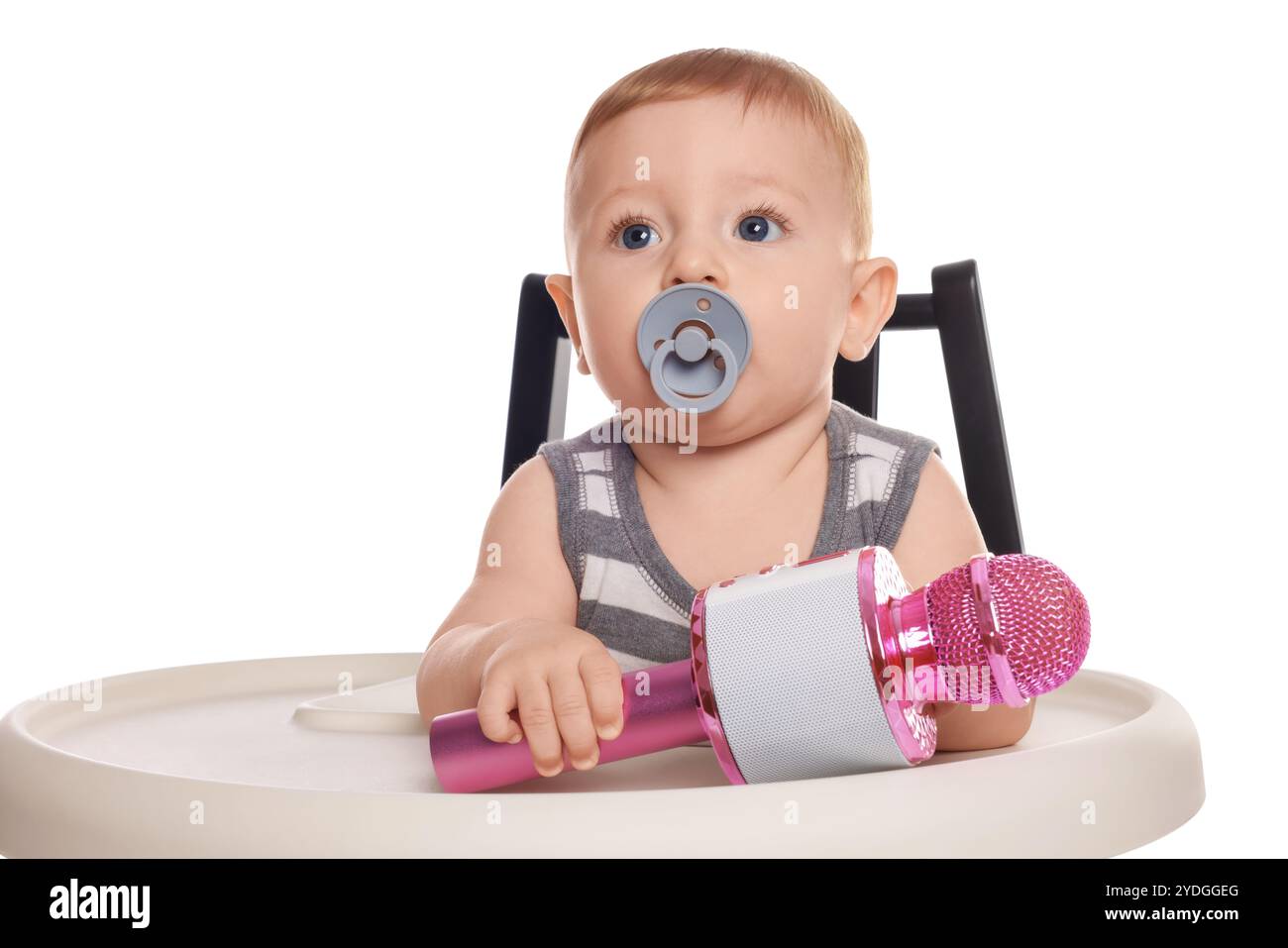 Cute little baby with pacifier and microphone in high chair on white ...