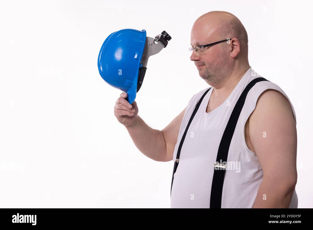 A worker is playfully holding a safety helmet, showcasing a fun and ...