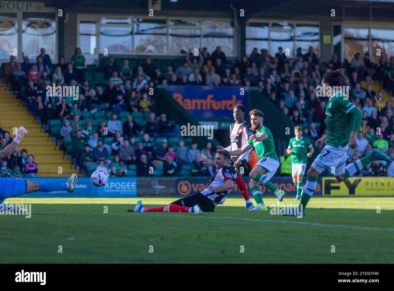 Aaron Jarvis of Yeovil Town slots ball past Craig Ross of Maidenhead ...