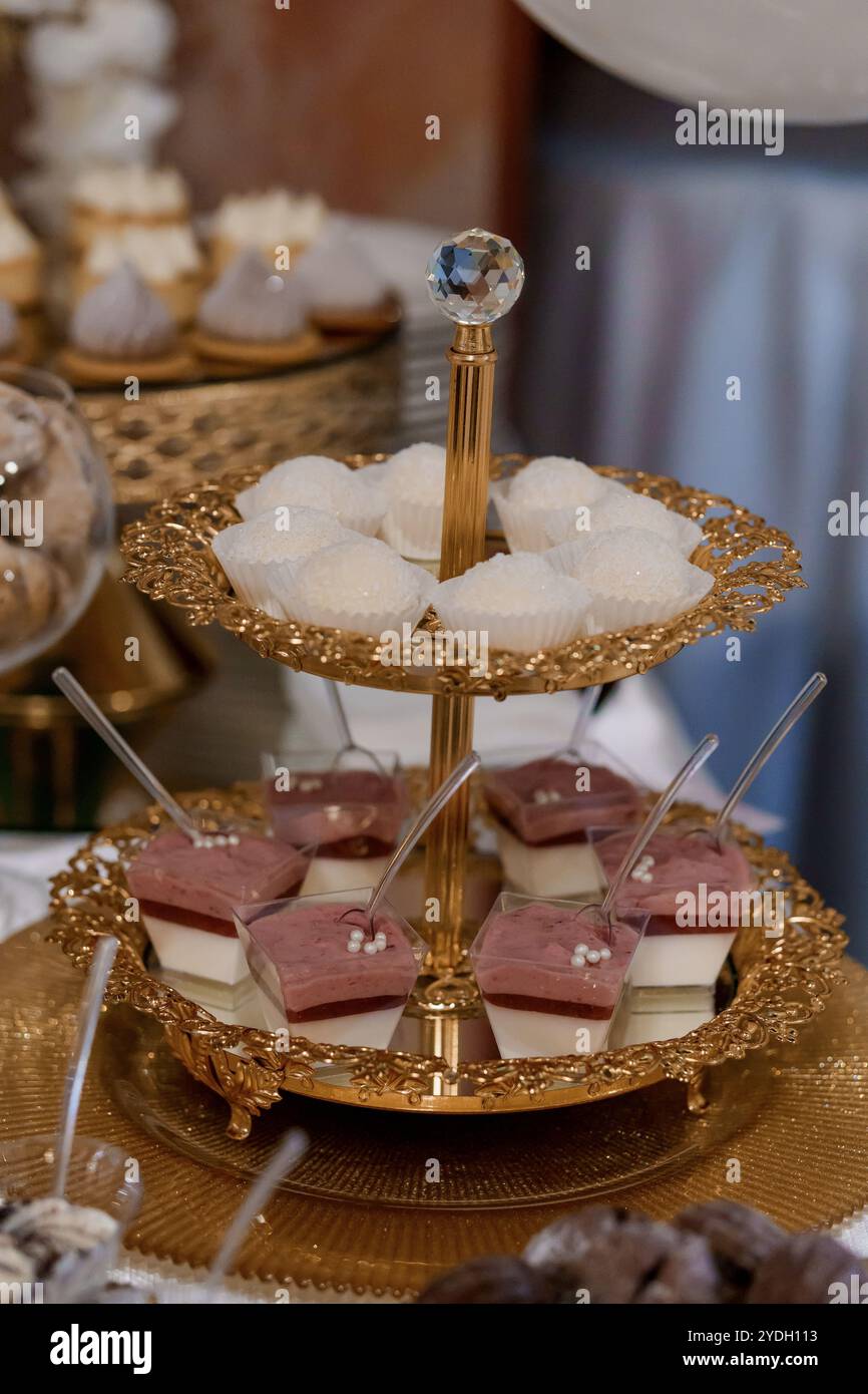 Elegant Dessert Display Featuring Layered Sweets on a Golden Stand ...