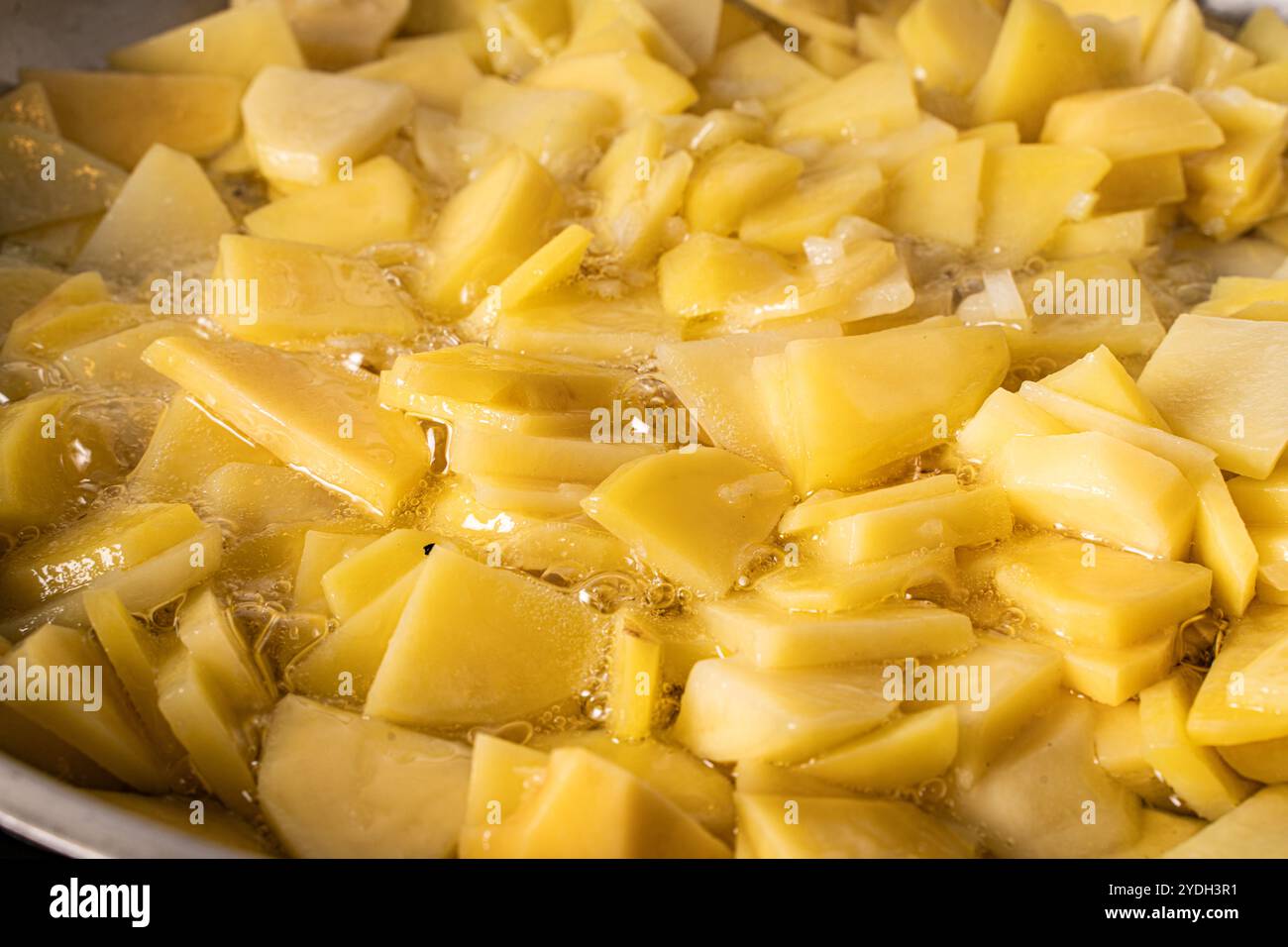 Potatoes are fried in a pan close-up. Background with potato texture ...