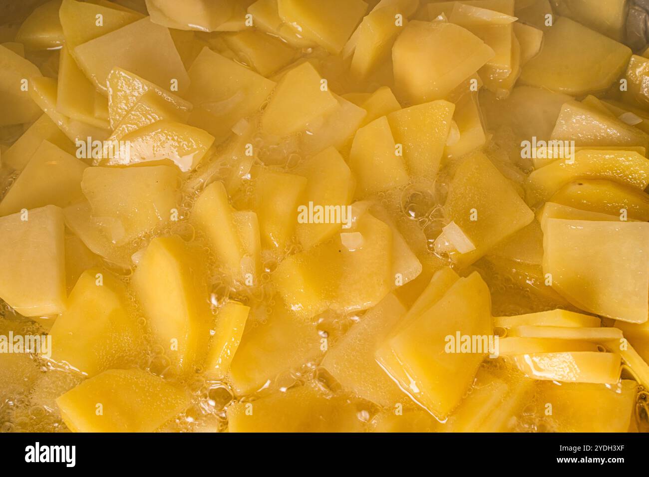 Potatoes are fried in a pan close-up. Background with potato texture ...