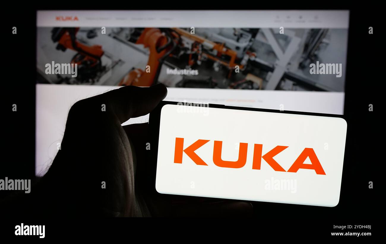 Person holding mobile phone with logo of German industrial automation ...