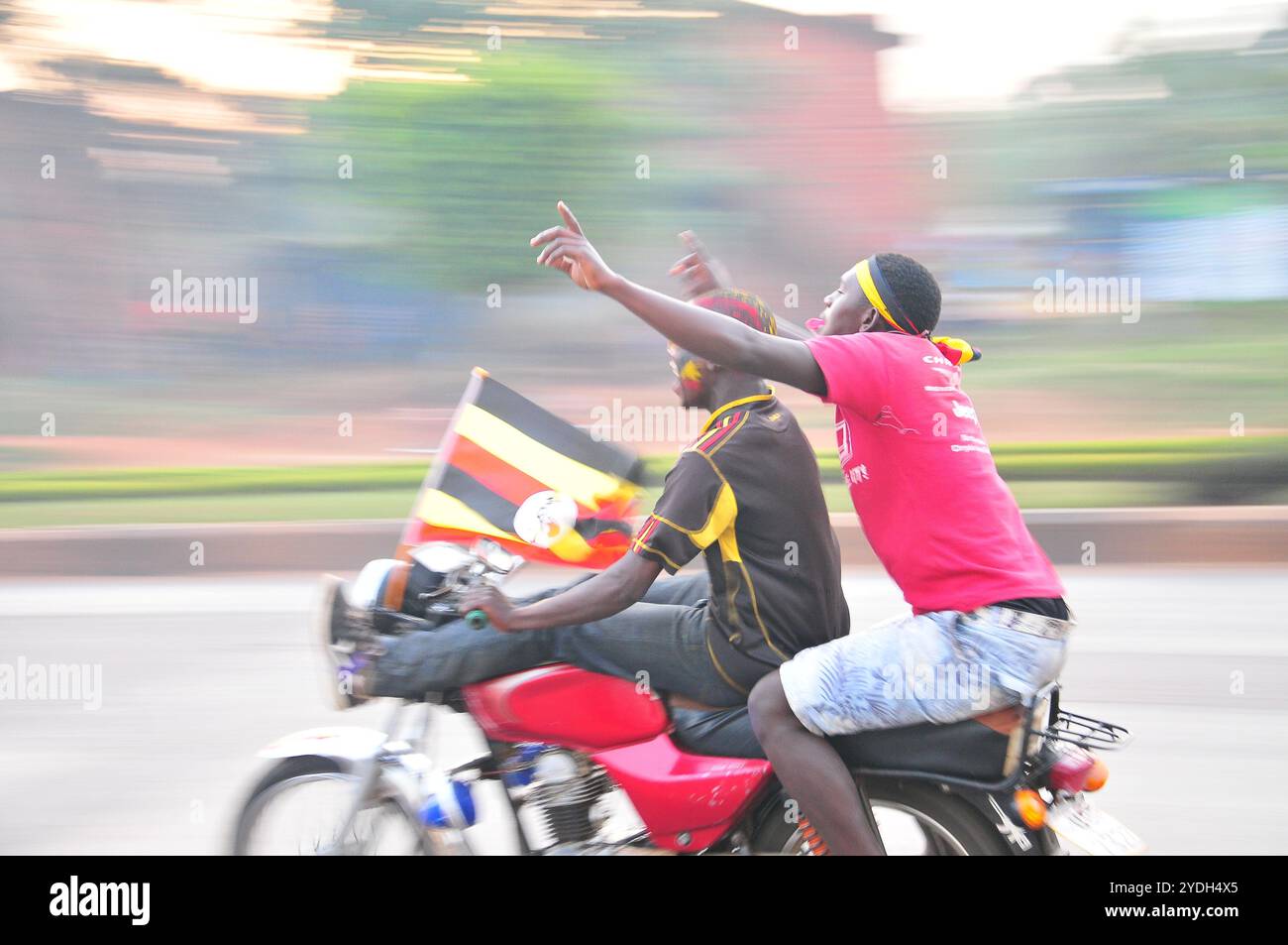 Uganda Football funs ride on a motorcycle celebrating a win for the ...