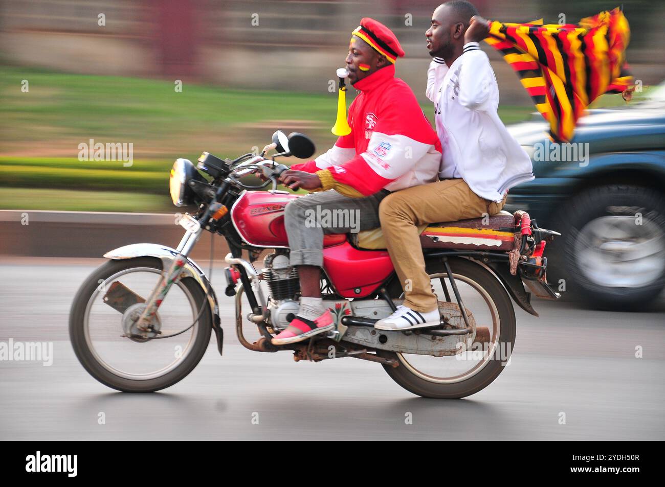 Uganda Football funs ride on a motorcycle celebrating a win for the ...