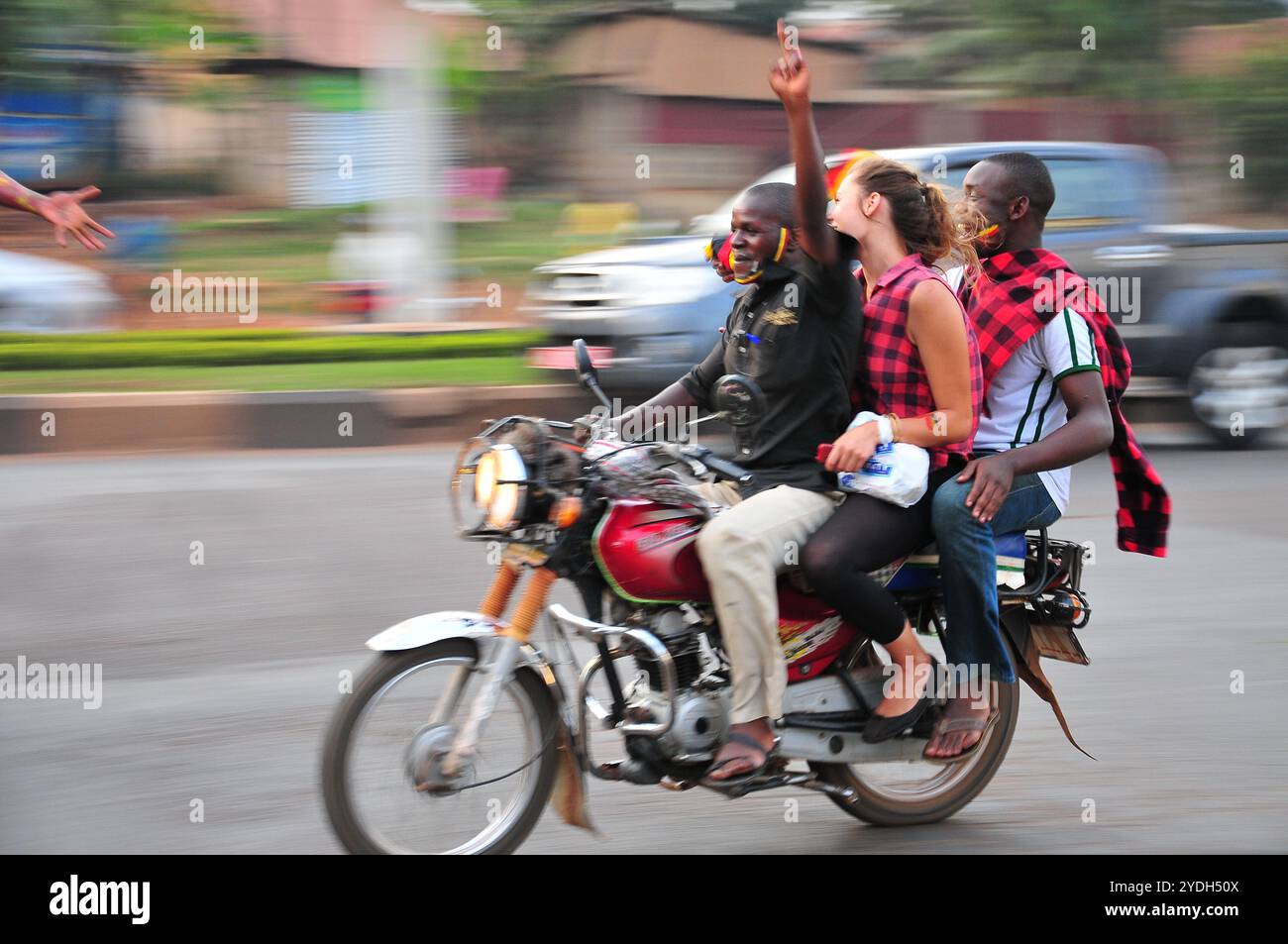 Uganda Football funs ride on a motorcycle celebrating a win for the ...