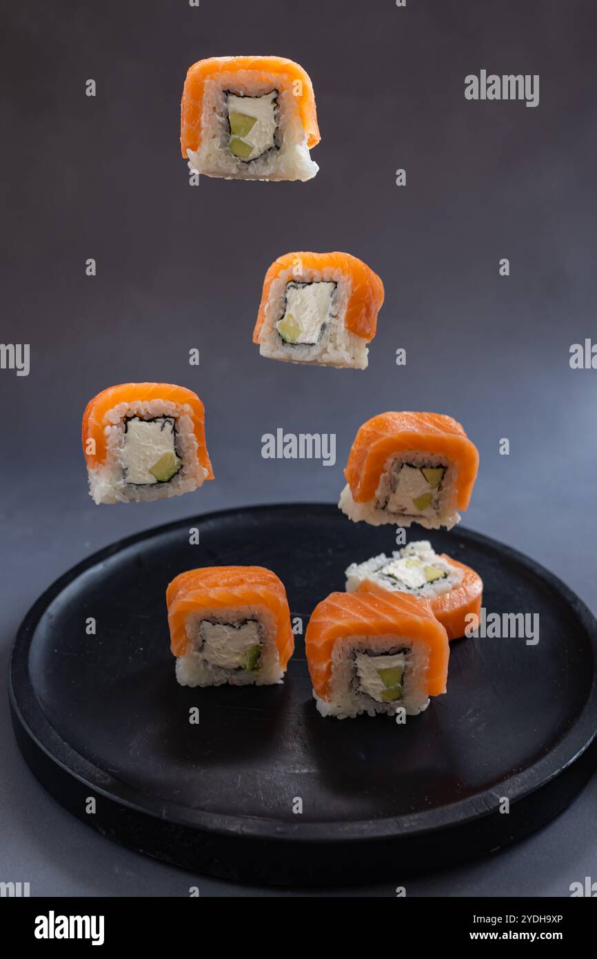 Floating salmon sushi roll with cream cheese and avocado in mid-air ...