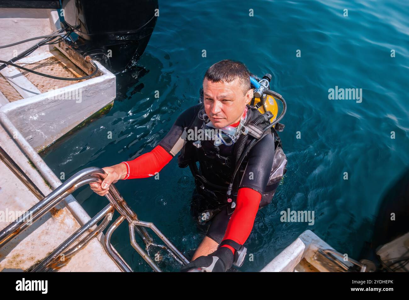 Satisfied diver climbing boat ladder after successful underwater ...