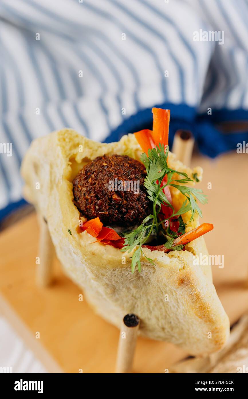Falafel wrap with fresh vegetables and herbs in pita bread ...