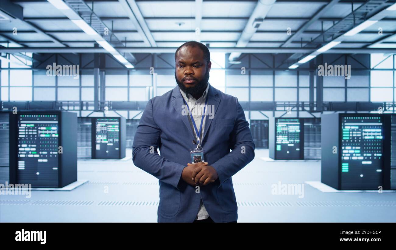 Technician walking between server rows in data center, doing yearly infrastructure inspection ...