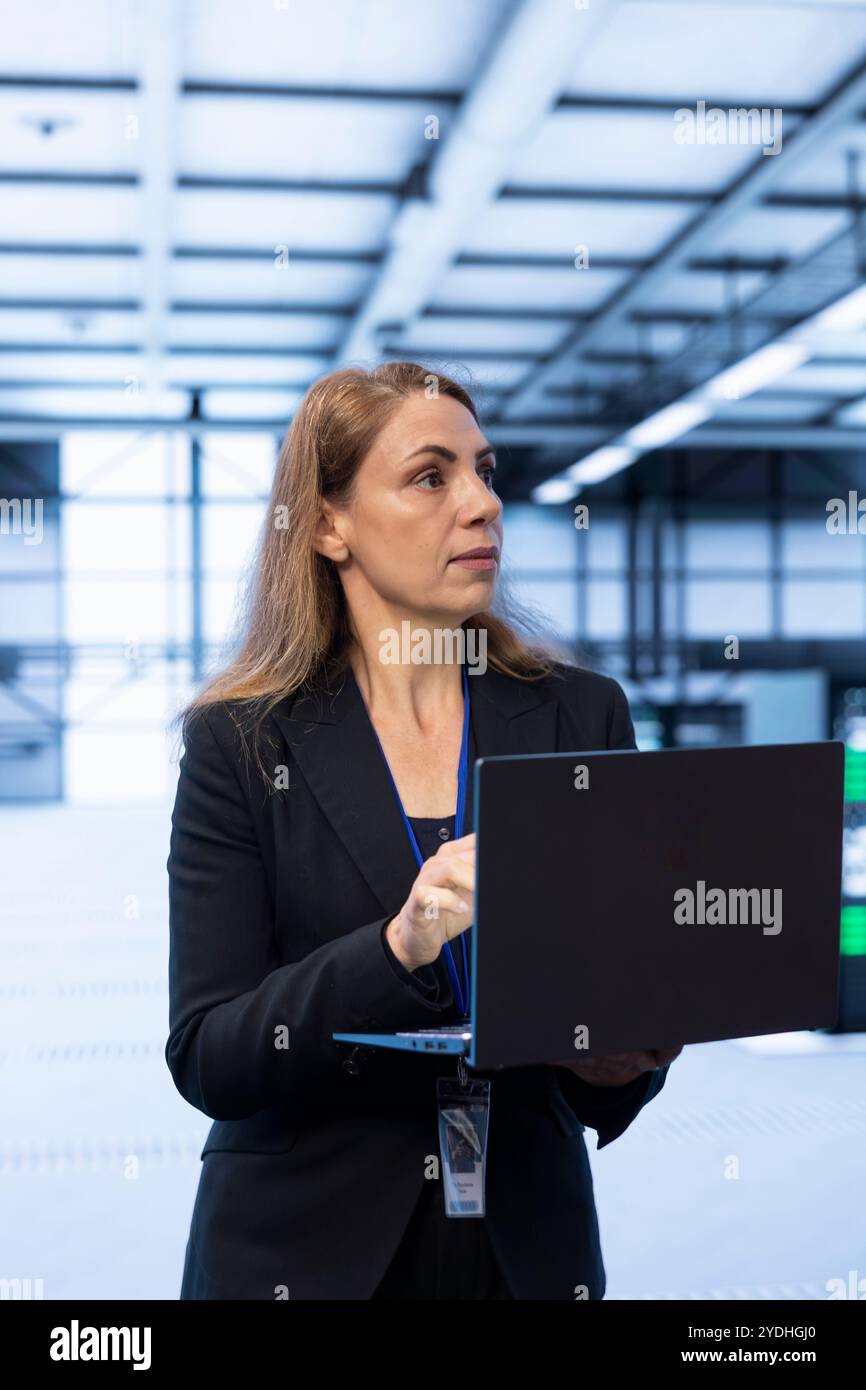Woman walking in data center, monitoring system performance with device ... Woman walking in data center, monitoring system performance with device ...