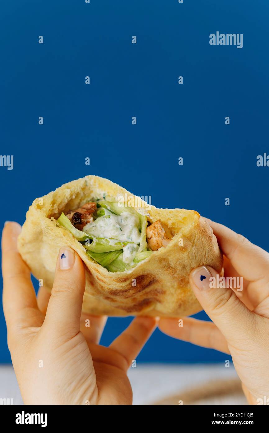 Pita wrap filled with grilled chicken, lettuce, and creamy sauce ...