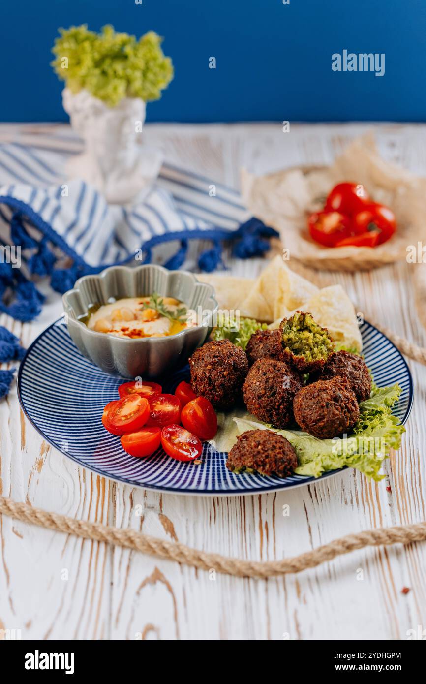 Falafel plate with hummus, cherry tomatoes, lettuce, and pita chips ...