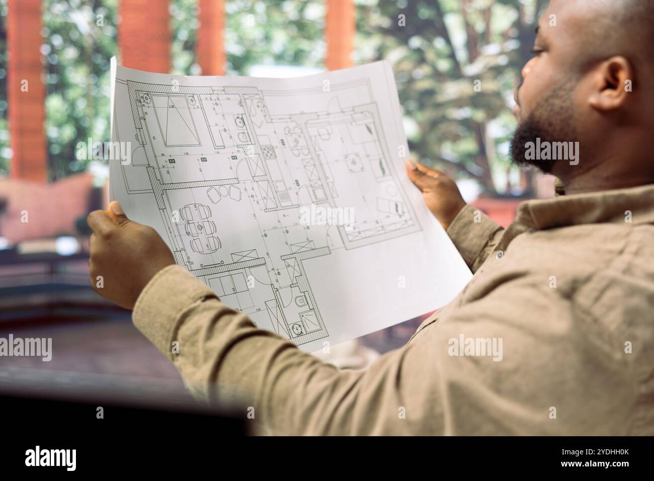 Entrepreneur reviewing architectural sketches and planning office space ...