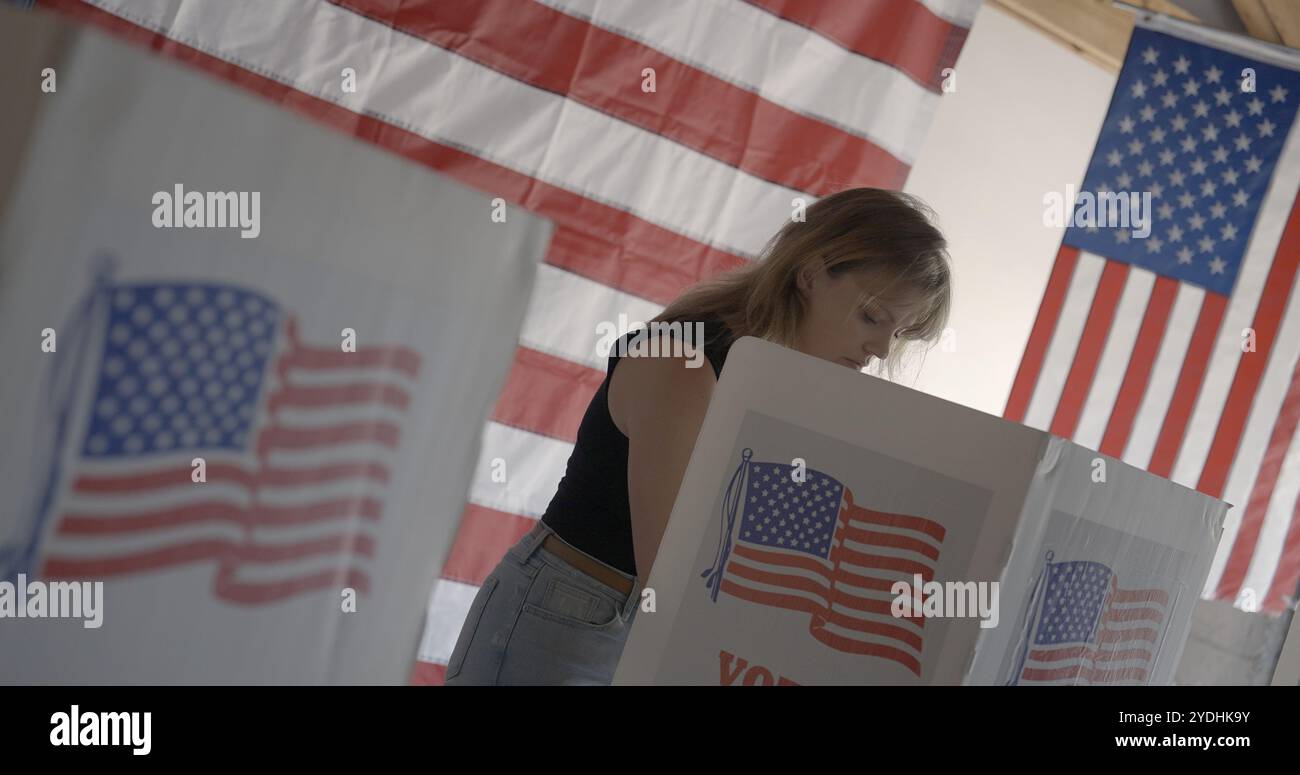 Angled camera, profile medium shot, young, red-haired woman casts votes ...