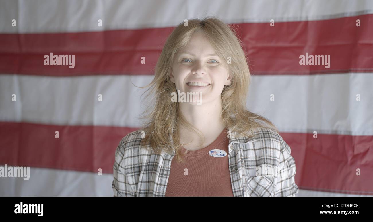 Close up, red-haired young woman wearing "I voted" sticker and smiling ...