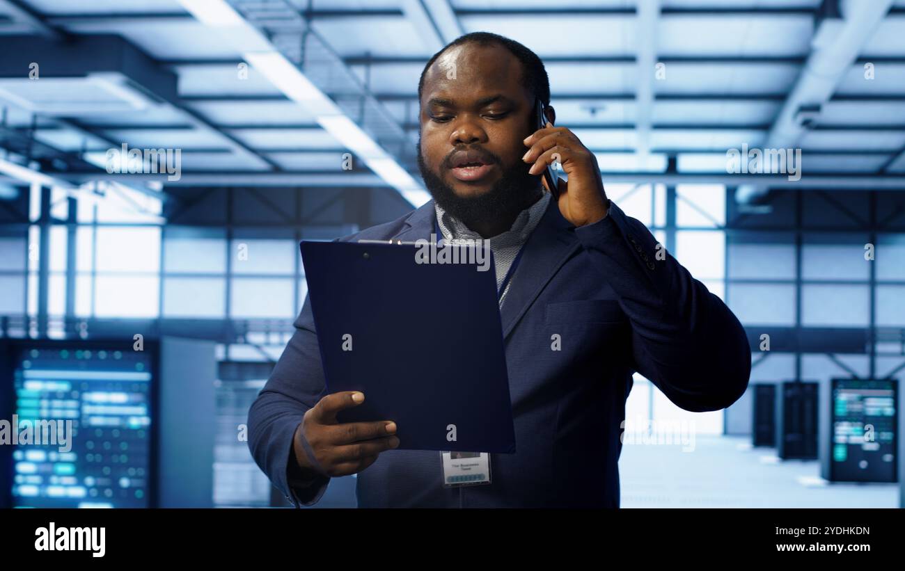 IT professional looking over data center checkup checklist paperwork ...