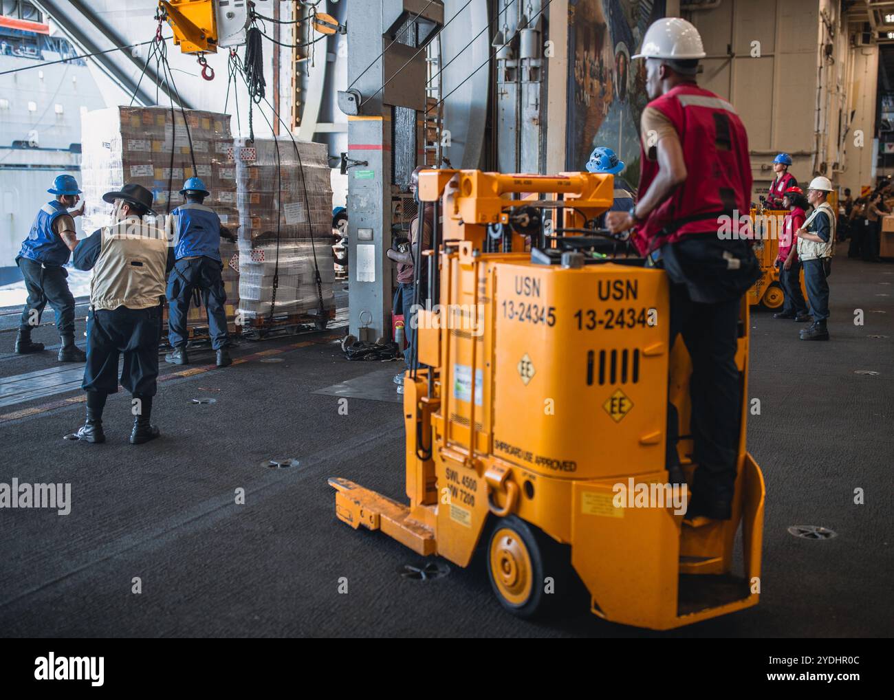 Sailors move pallets of cargo in the hangar bay aboard Nimitz-class ...