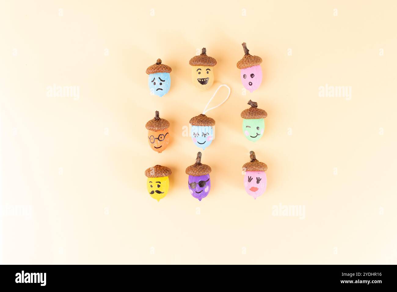 nine acorns painted in various colors with different facial expressions ...