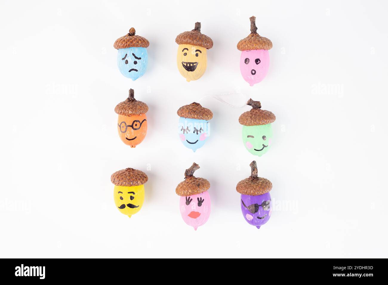 nine acorns painted in various colors with different facial expressions ...