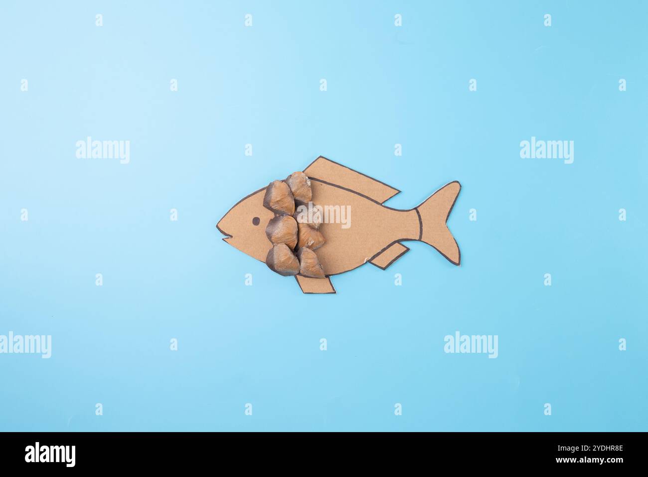 cardboard cut into the shape of a fish, with small pine cone scales ...