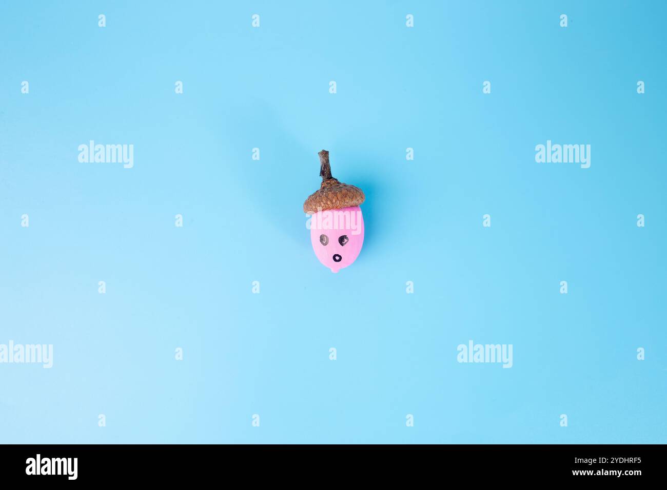 Acorn with pink painted body and brown cap, black dots for eyes, small ...