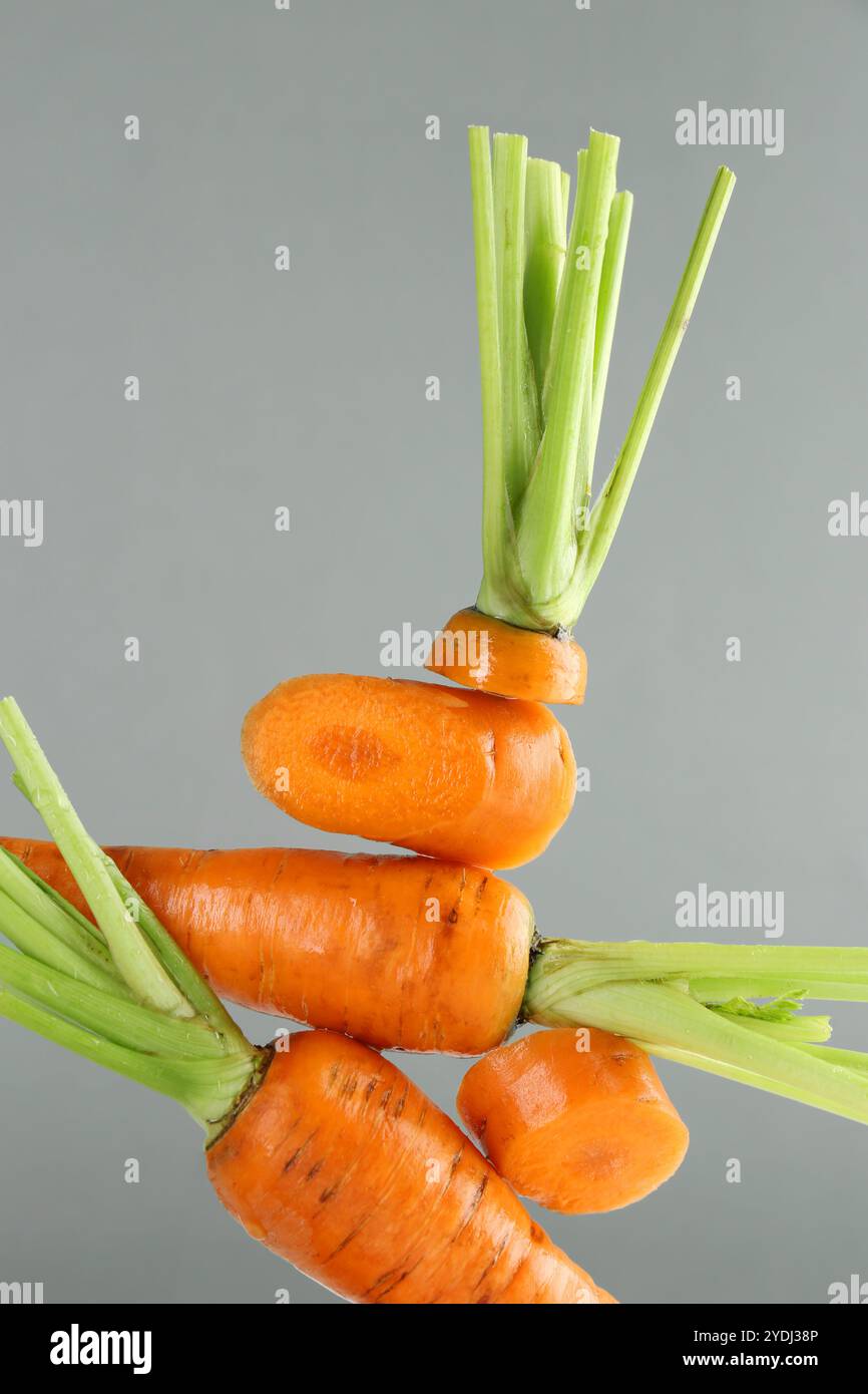 Whole and cut fresh carrots on green background, closeup Stock Photo ...