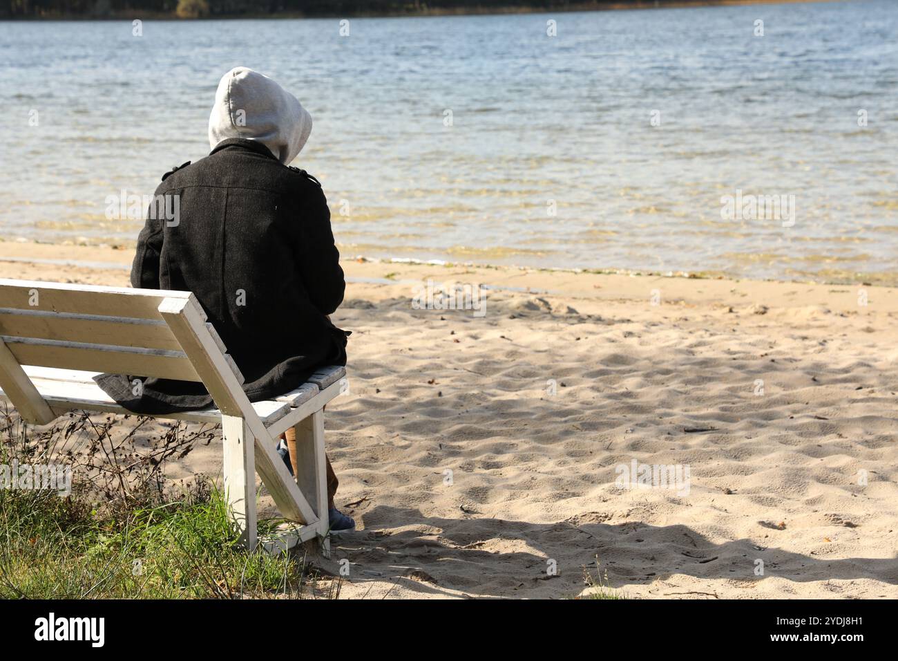 Loneliness concept. Sad man sitting on bench at beach Stock Photo - Alamy