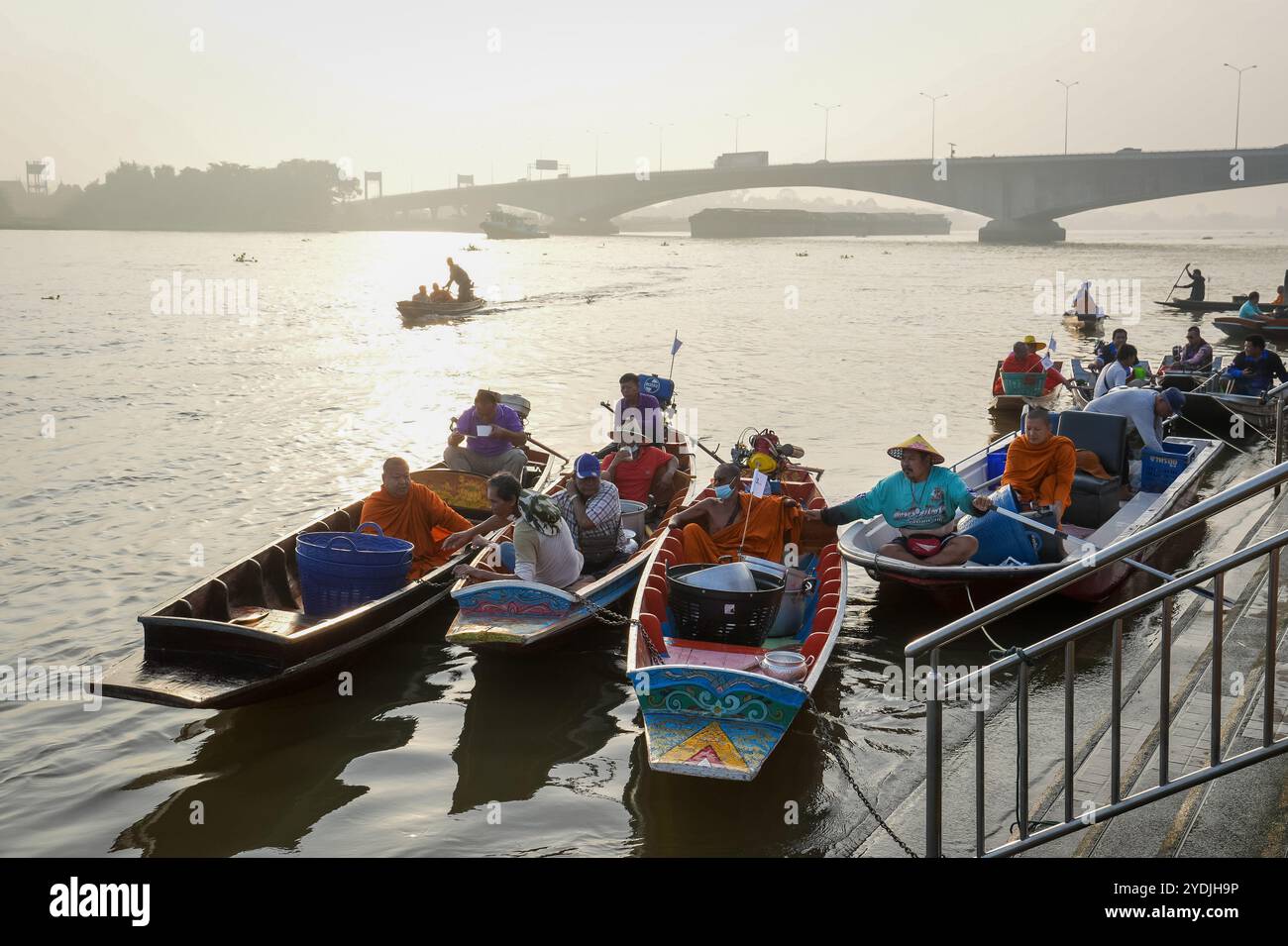 A view of several rowboats at sunrise, with monks and their helpers ...