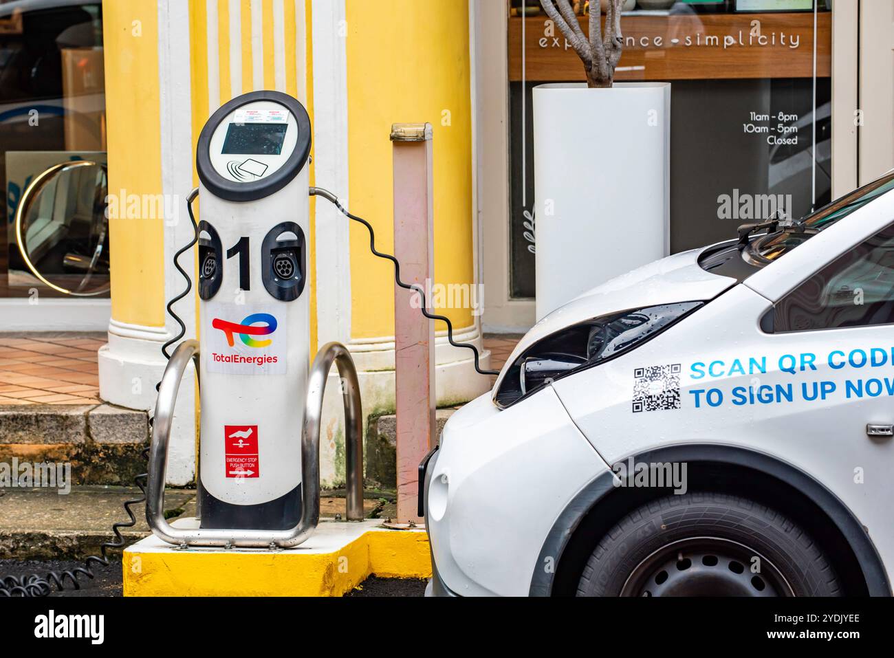 An electric EV hire car connected to a Total Energies EV charging point ...