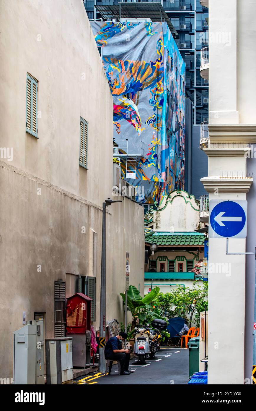 A worker rests near the giant multilevel mural by Sean Dunston in 2022 ...