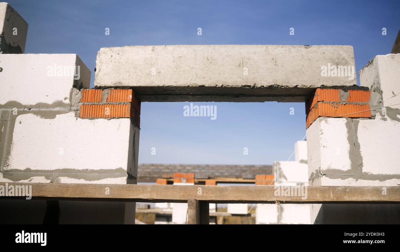 Construction workers engaged in installing a concrete lintel for a ...