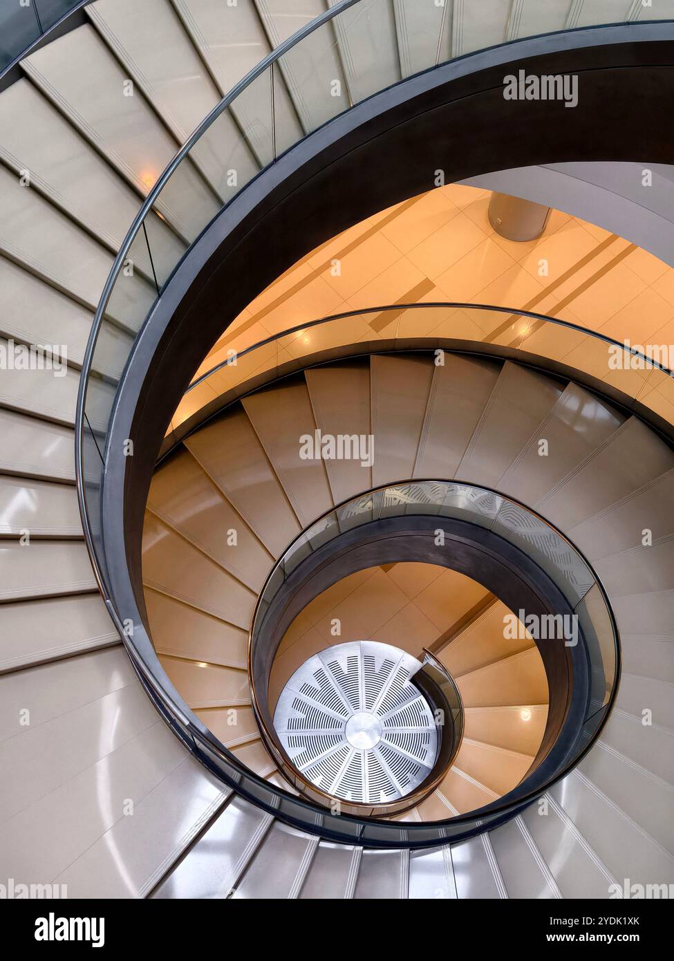 A beautifully designed spiral staircase in a modern building with glass ...
