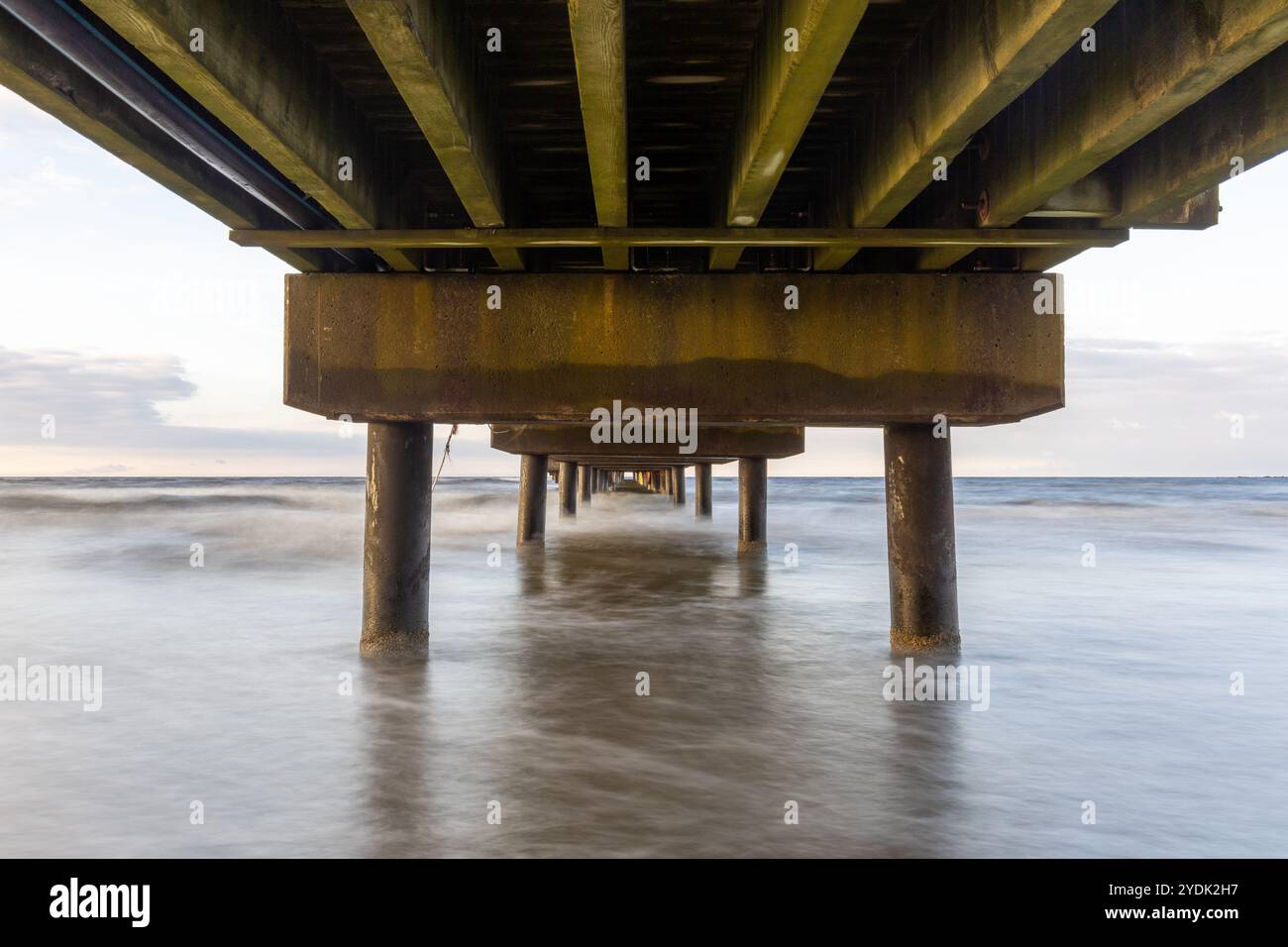 Long exposure under pier looking out to sea Stock Photo - Alamy