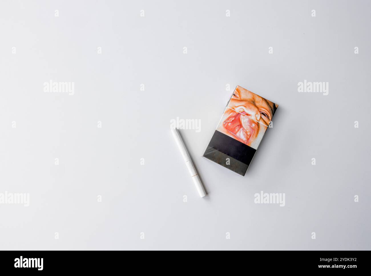cigarette and its pack displayed on a plain surface, showcasing a ...