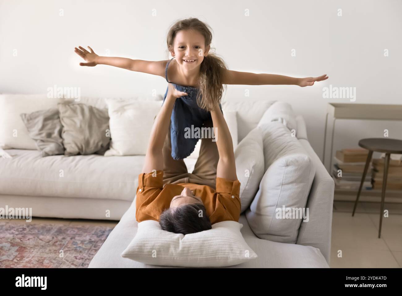 Strong daddy lifting little daughter kid up in air Stock Photo - Alamy
