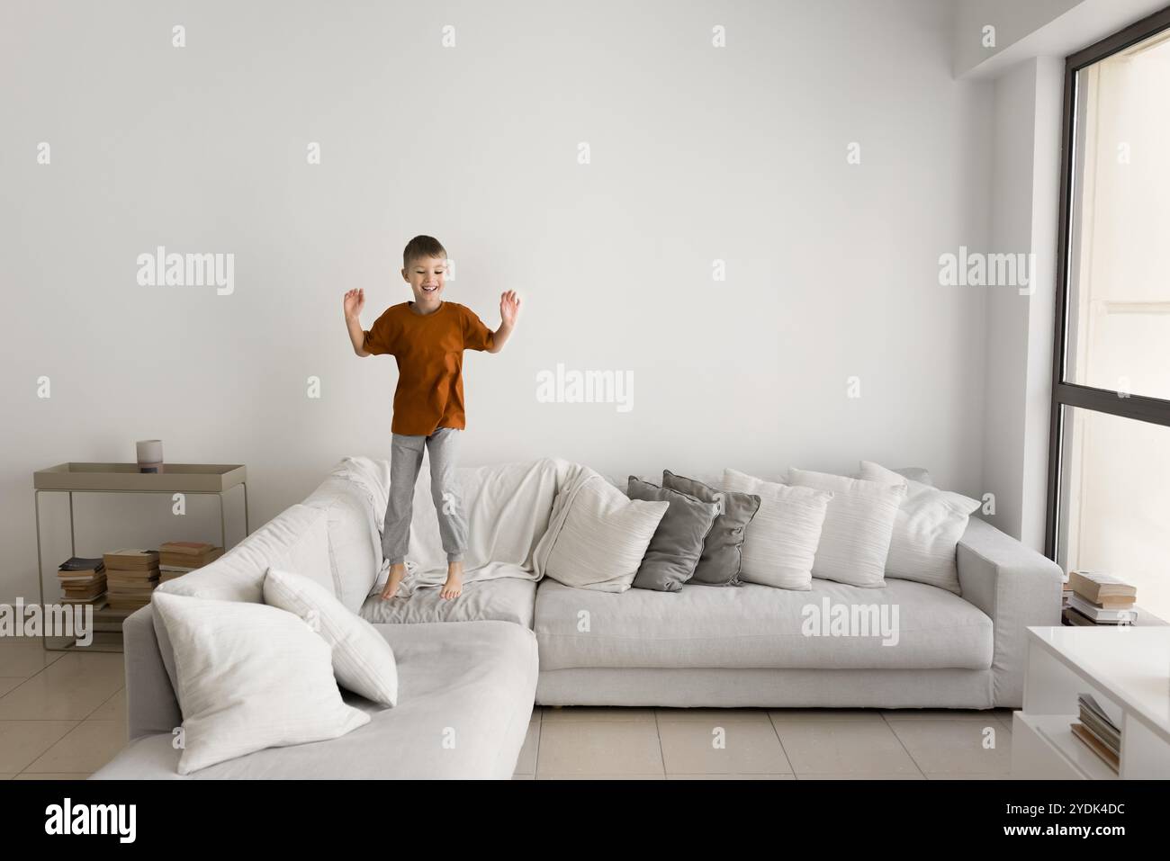 Happy active boy kid jumping on large soft couch Stock Photo - Alamy
