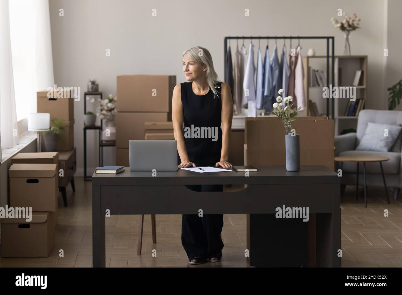 Thoughtful smiling older lady take break at work look aside Stock Photo ...