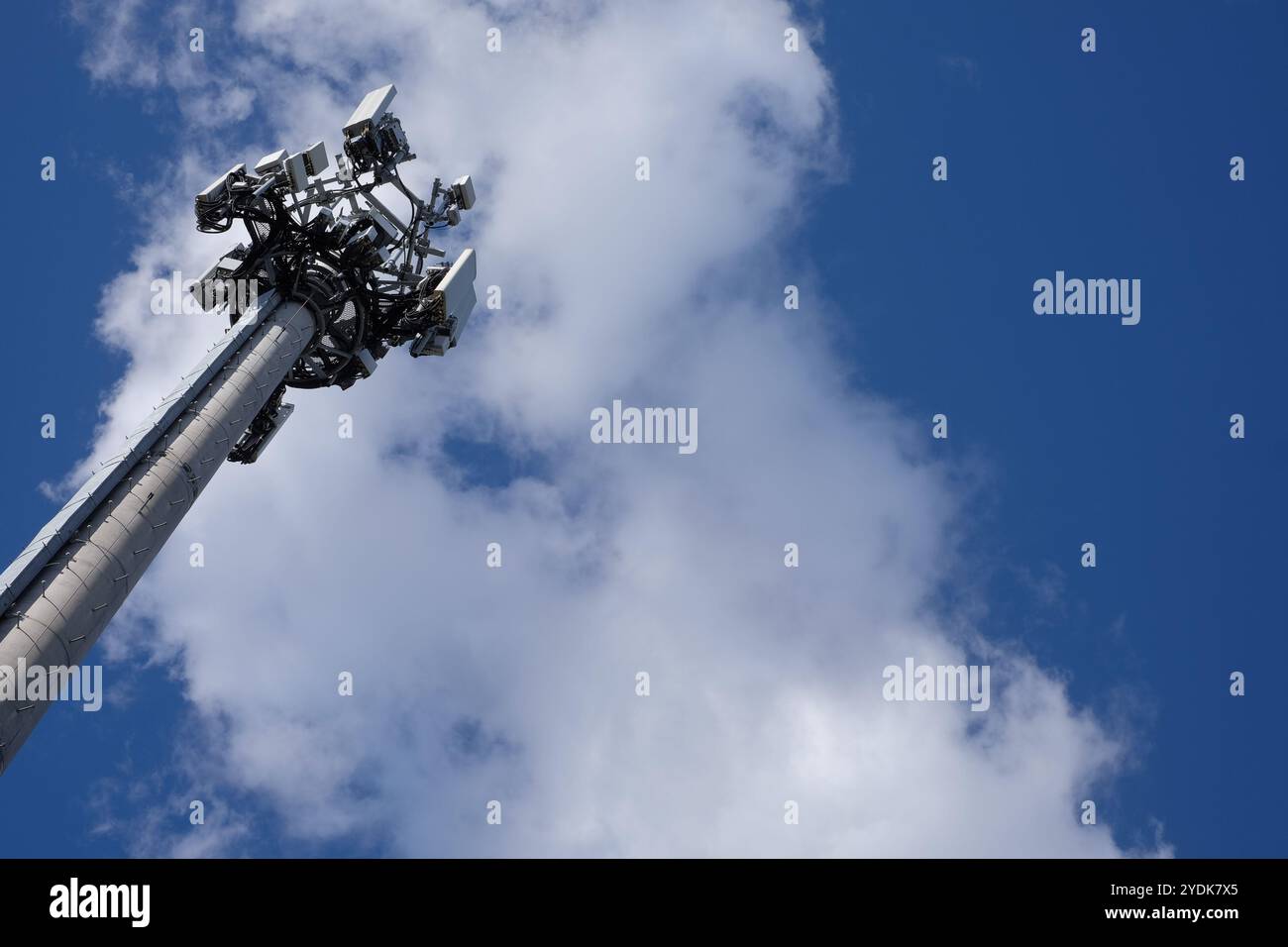 MTOWER, monopole Comms tower with antennas against white cloud and a blue Australian sky in ...
