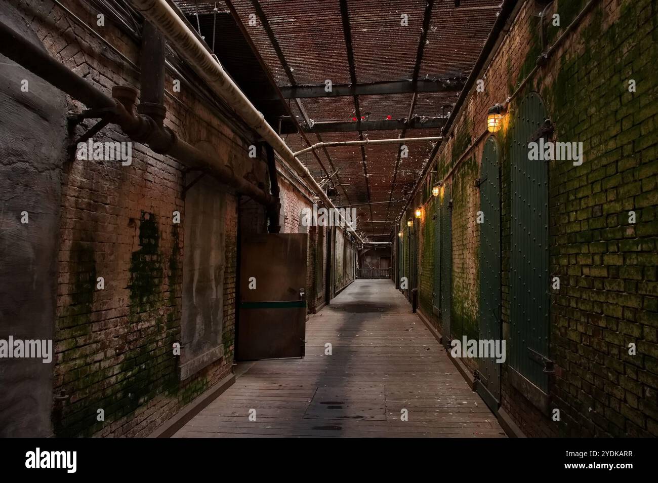 Hallway in prison with brick walls and metal doors Stock Photo - Alamy