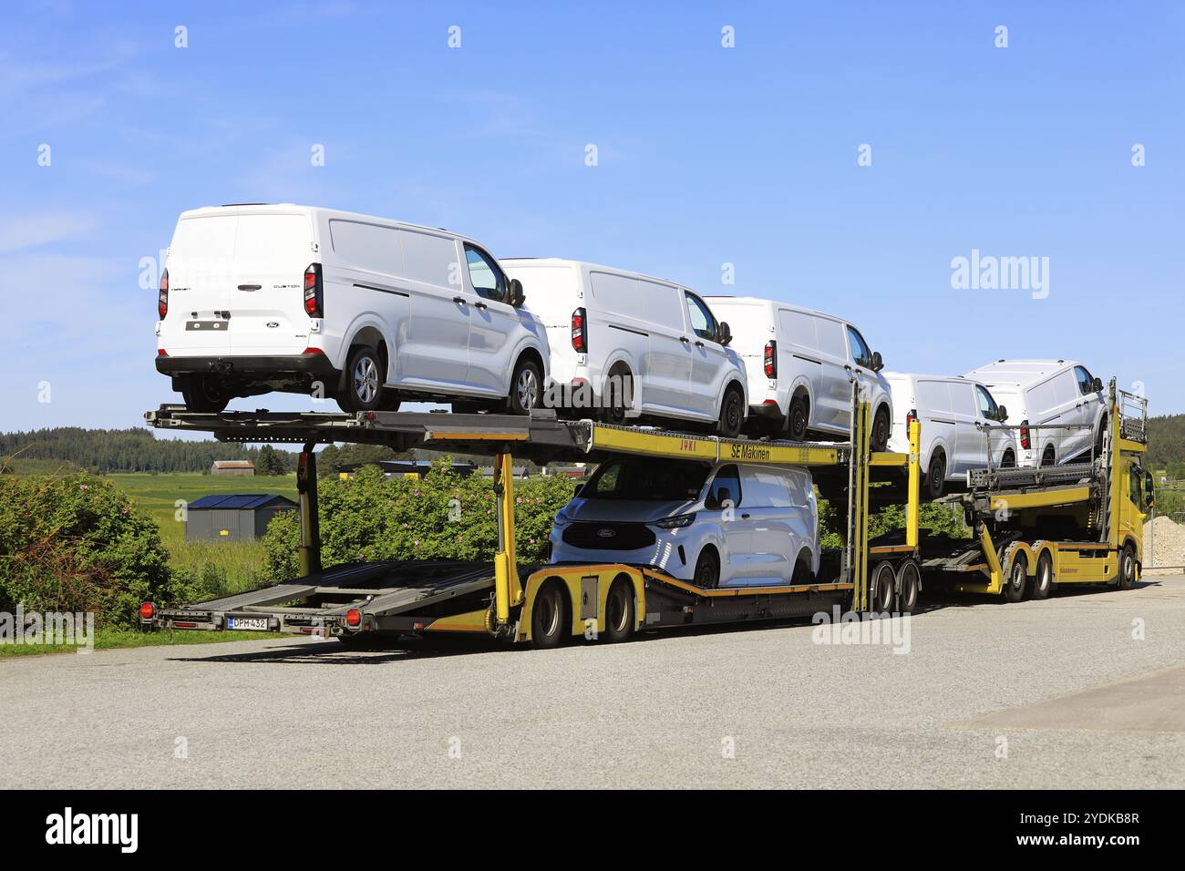Yellow Volvo vehicle carrier truck transports six new, white Ford ...