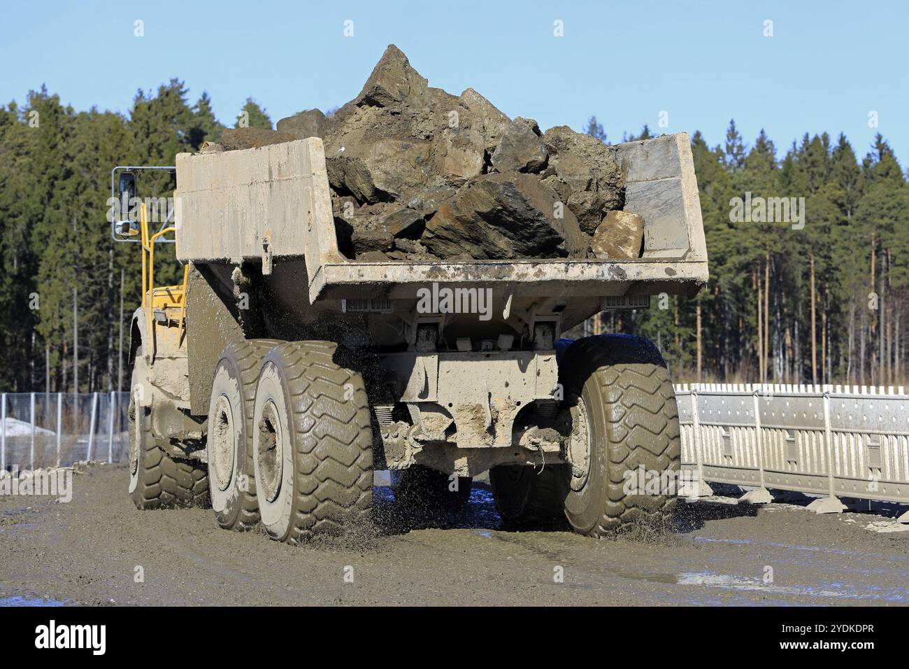 Articulated dumper with load of stone and gravel at work on a muddy ...