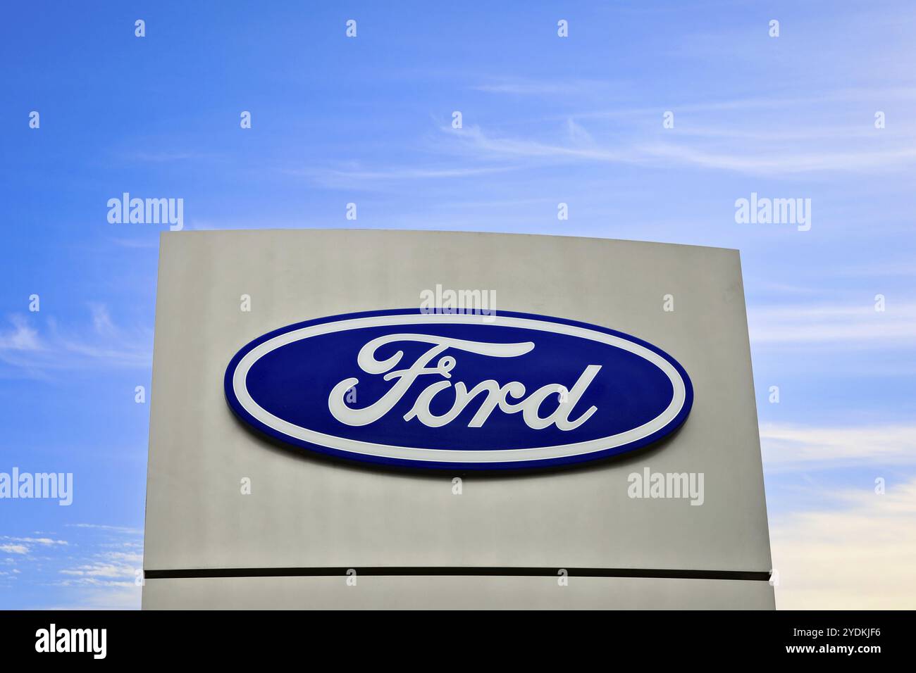 Ford Motor Company logo at dealership against blue sky. The company was ...