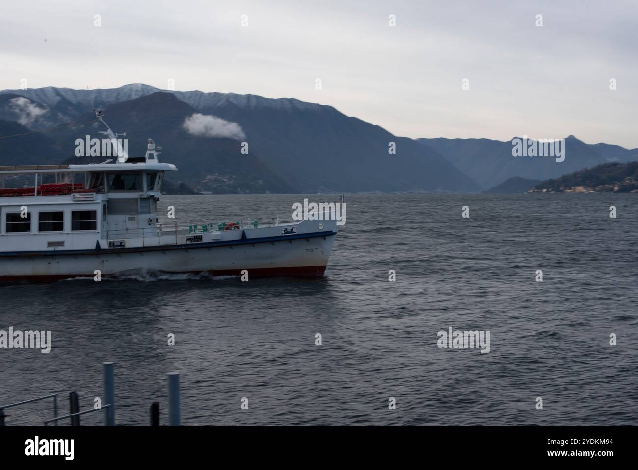 bow of old ferry sailing on lake with white colors and mountains in ...