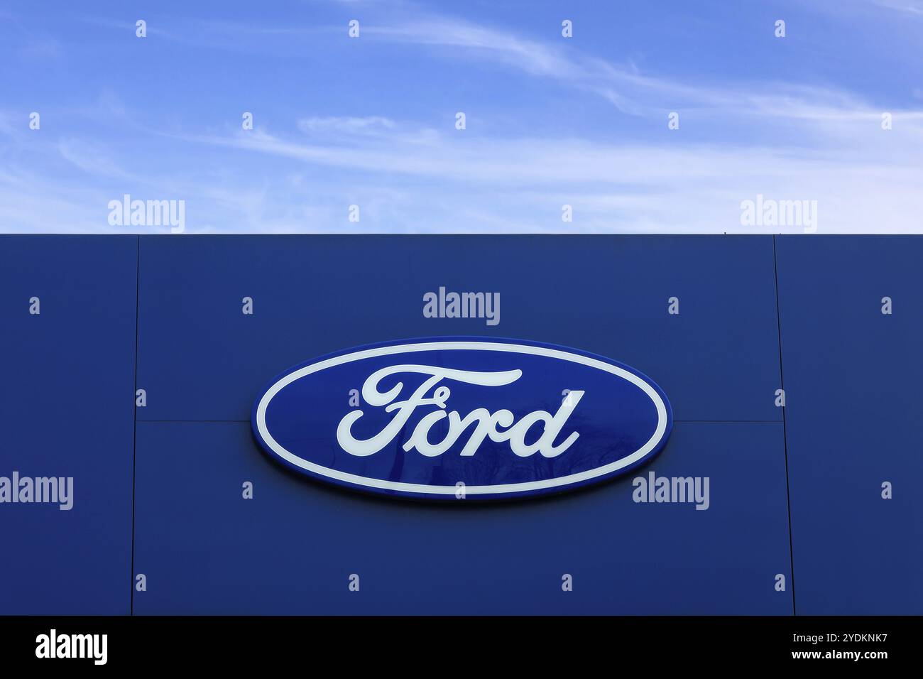 Ford Motor Company logo at dealership against blue sky. The company was ...