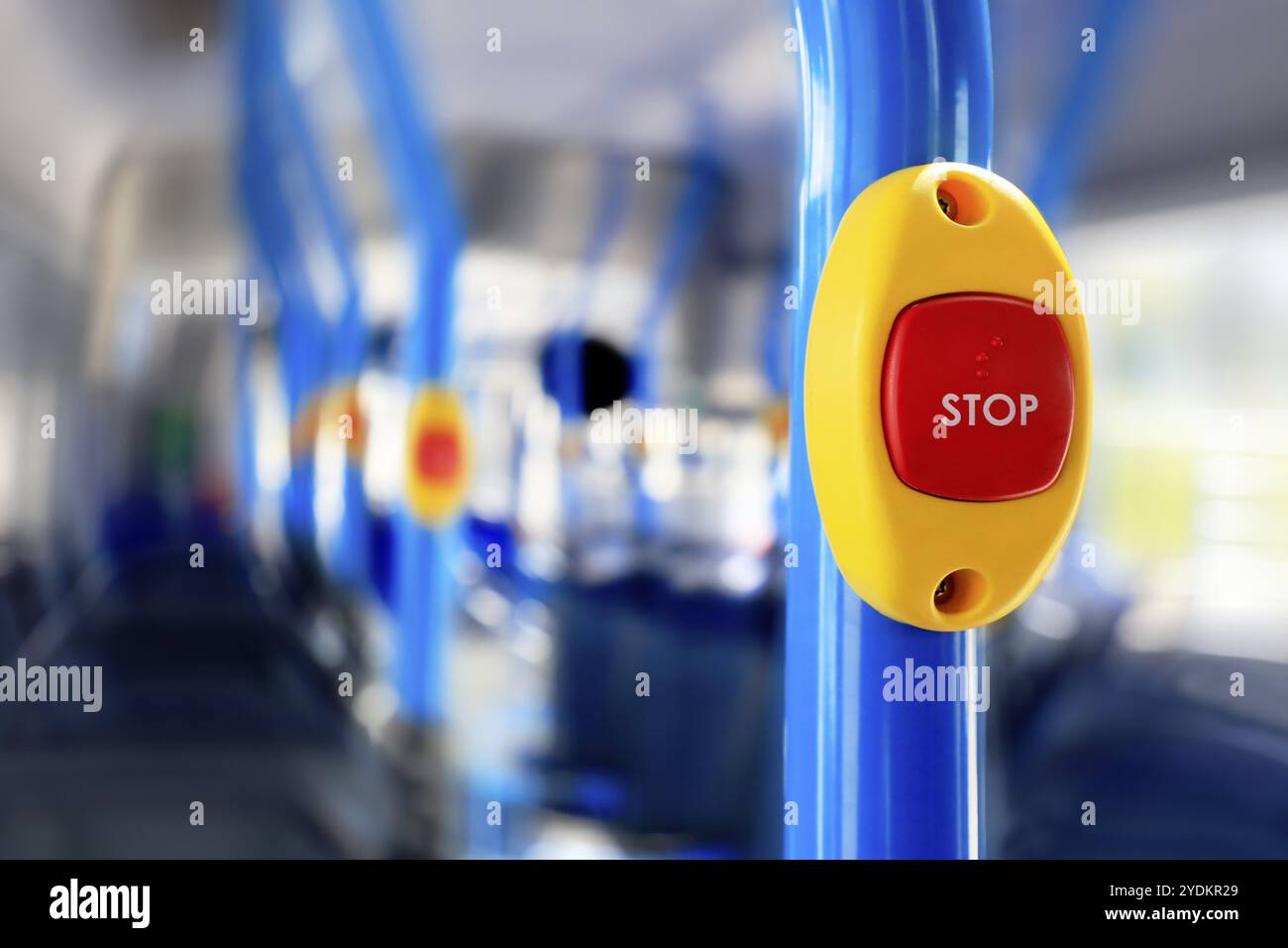 Stop button on a colorful modern city bus close up. Blurred background ...