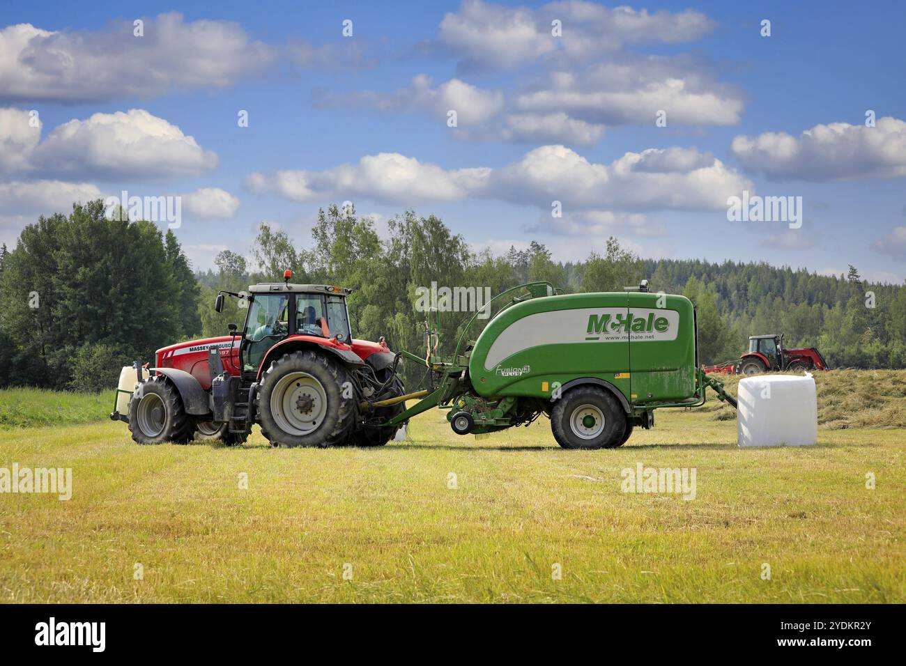 Massey-Ferguson tractor in hay field with McHale baler wrapper ...