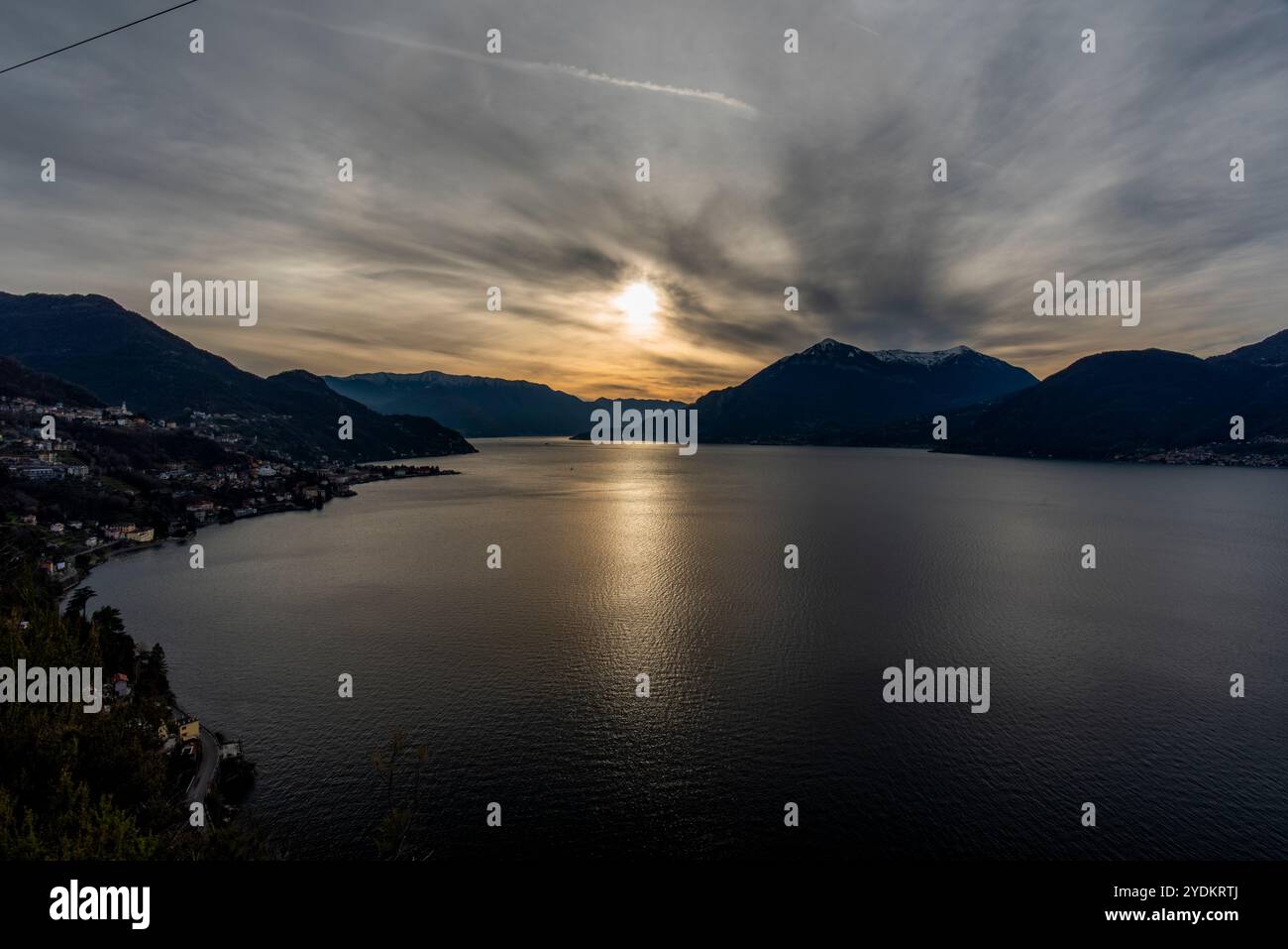 view of Lake Como between high mountains green trees with rocks on the ...