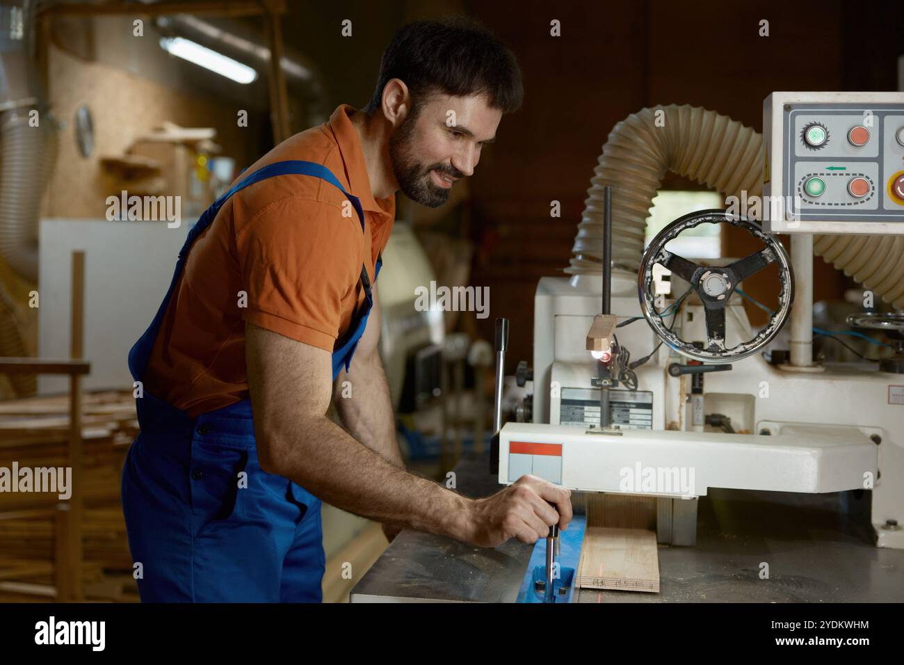 Workman using planer machine for production wooden materials specific ...