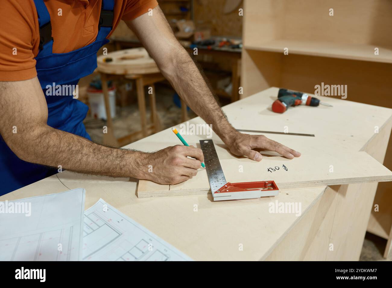 Handyman measuring with ruler during furniture production process at ...
